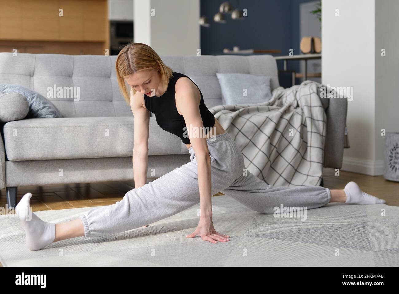 Woman working up forward splits warming up her legs Stock Photo - Alamy