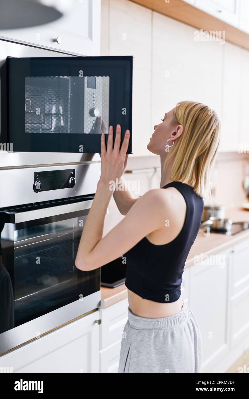 Woman opened the microwave oven Stock Photo - Alamy