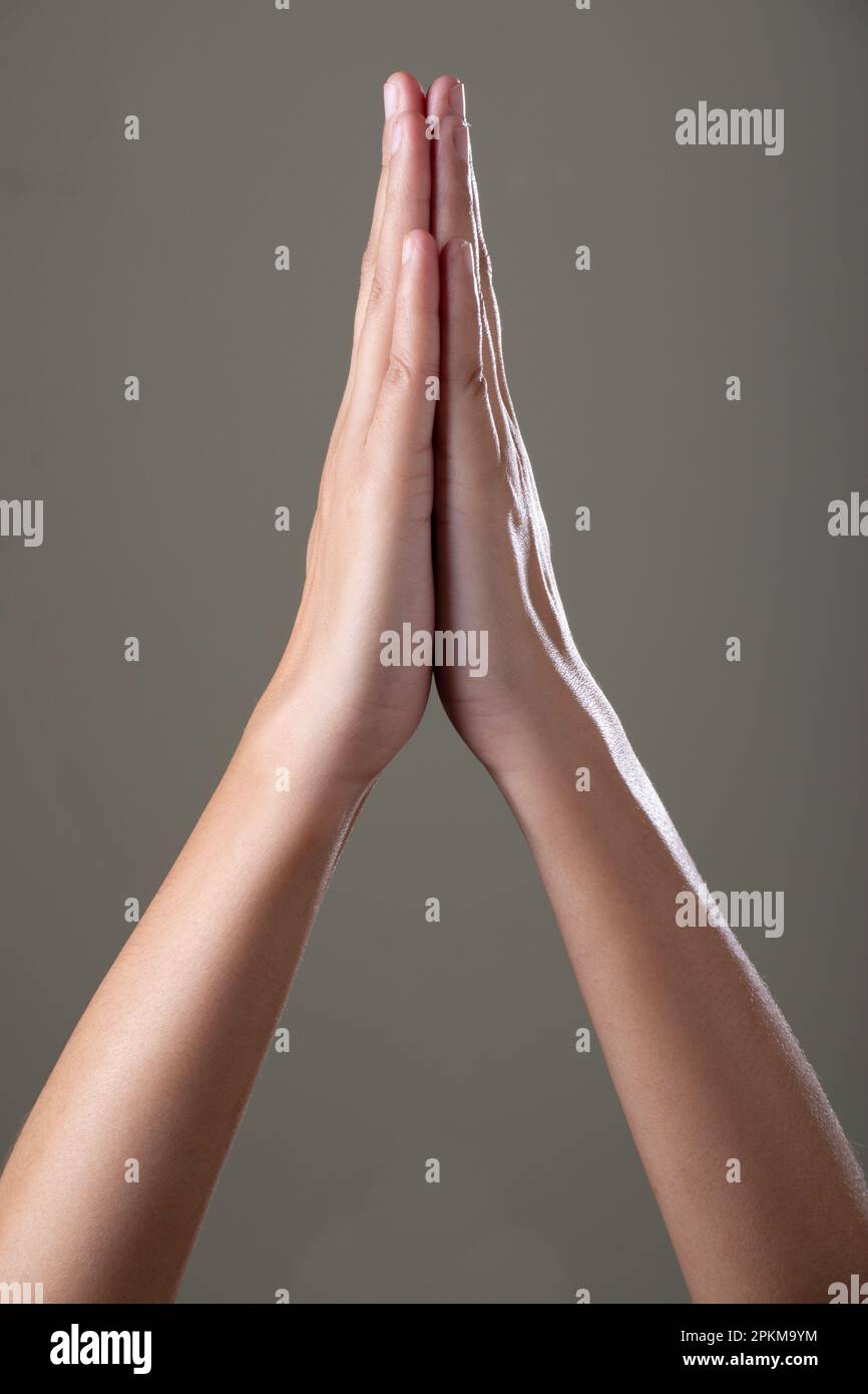 Closeup of namaste hand gesture on grey background Stock Photo - Alamy