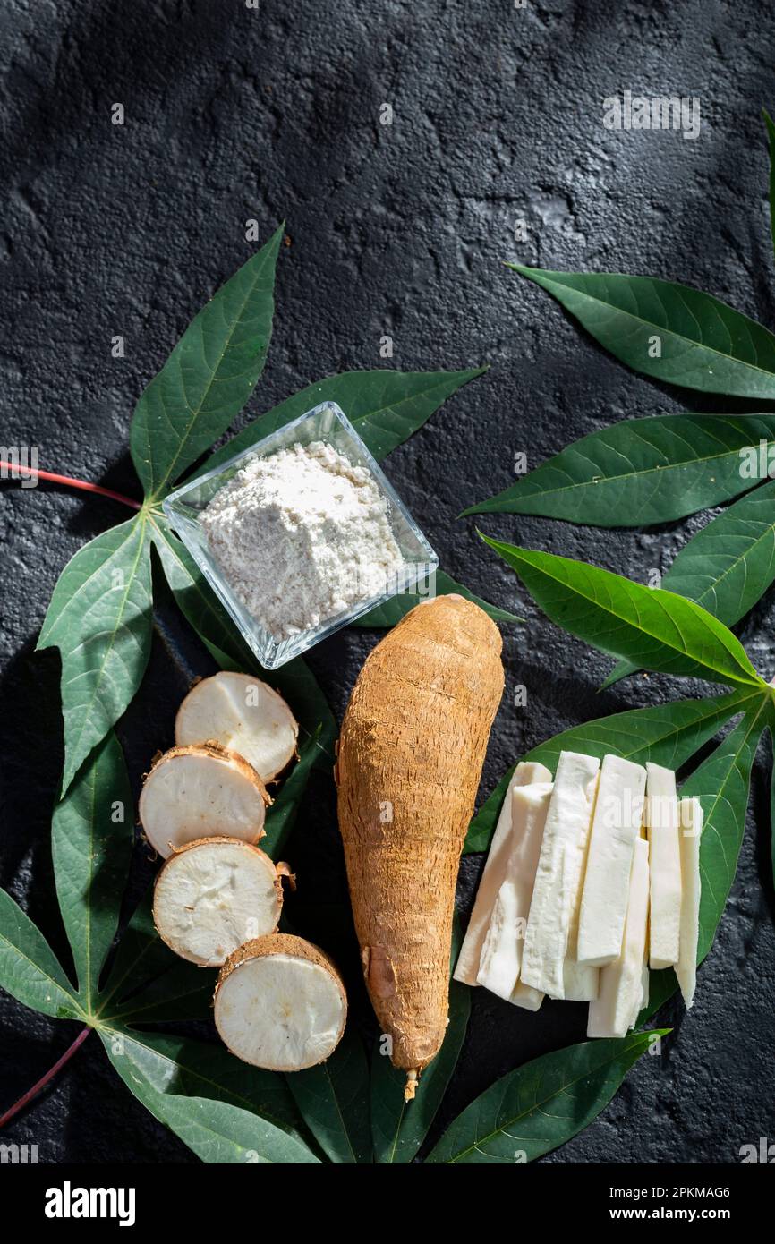 pile of cassava fruit and cassava flour on a background of rustic and ...