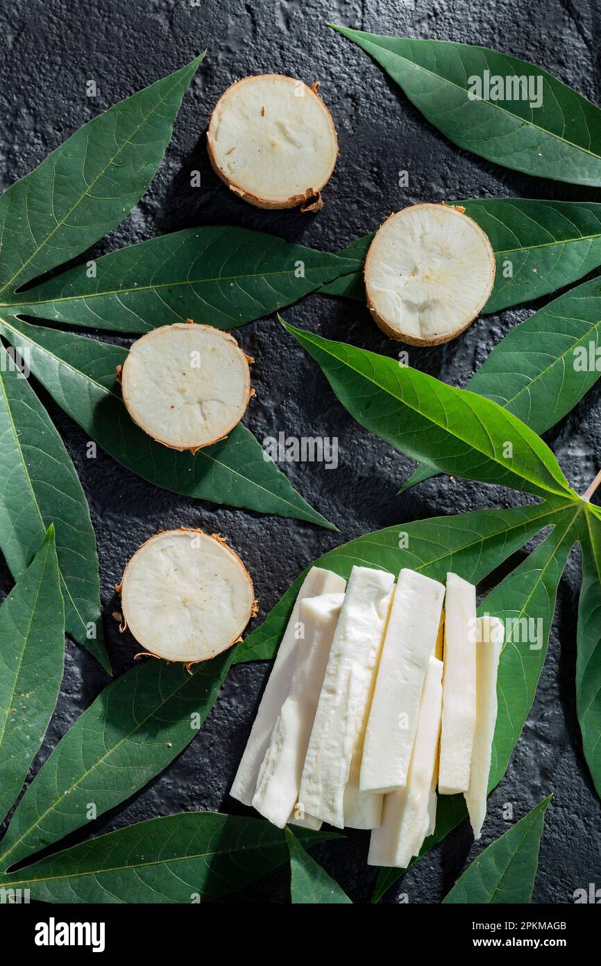 pile of cassava fruit and cassava flour on a background of rustic and ...