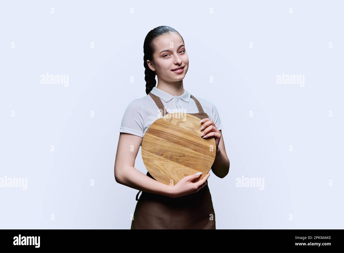 Young female student waitress in an apron with wooden empty tray on ...