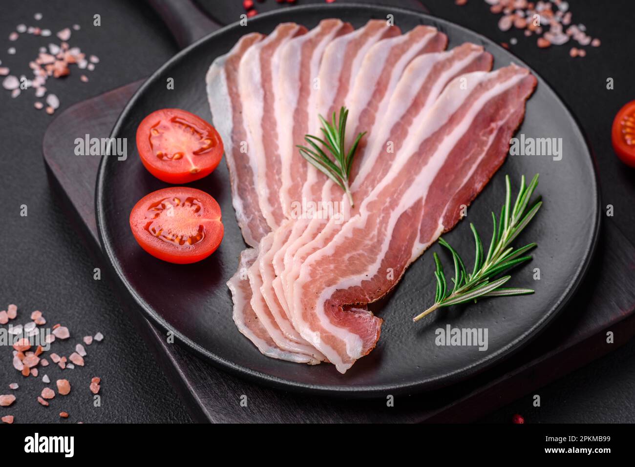 Delicious fresh pancetta with salt and spices cut into thin slices on a ...