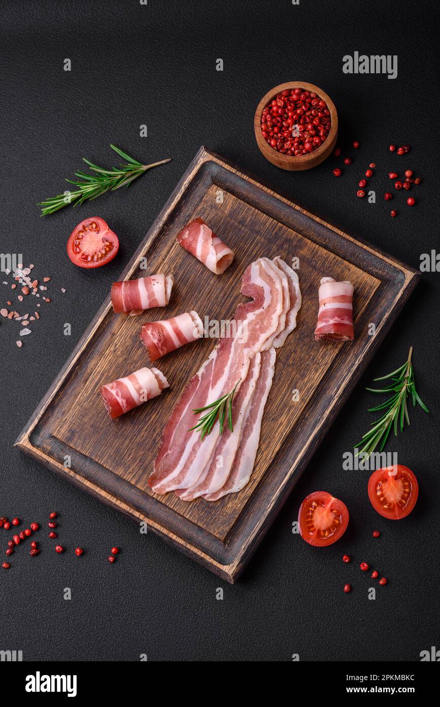 Delicious fresh pancetta with salt and spices cut into thin slices on a ...