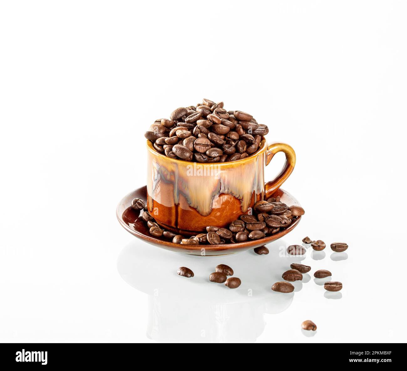 Coffee theme. A ceramic cup filled to the brim with coffee beans stands ...