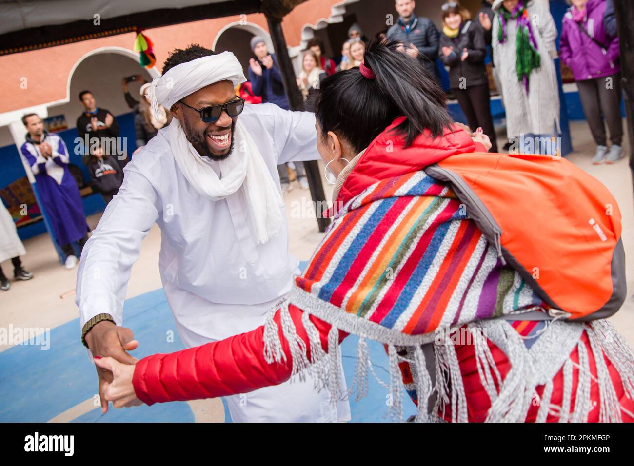 A group of tourists cheer on a dancing man and woman at Dar Gnaoua ...