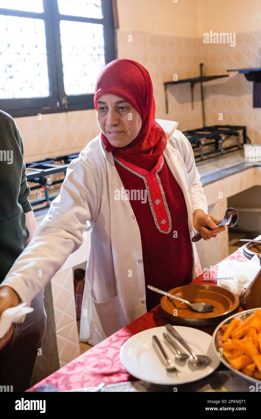 A Moroccan woman helps serve food in a kitchen Stock Photo - Alamy