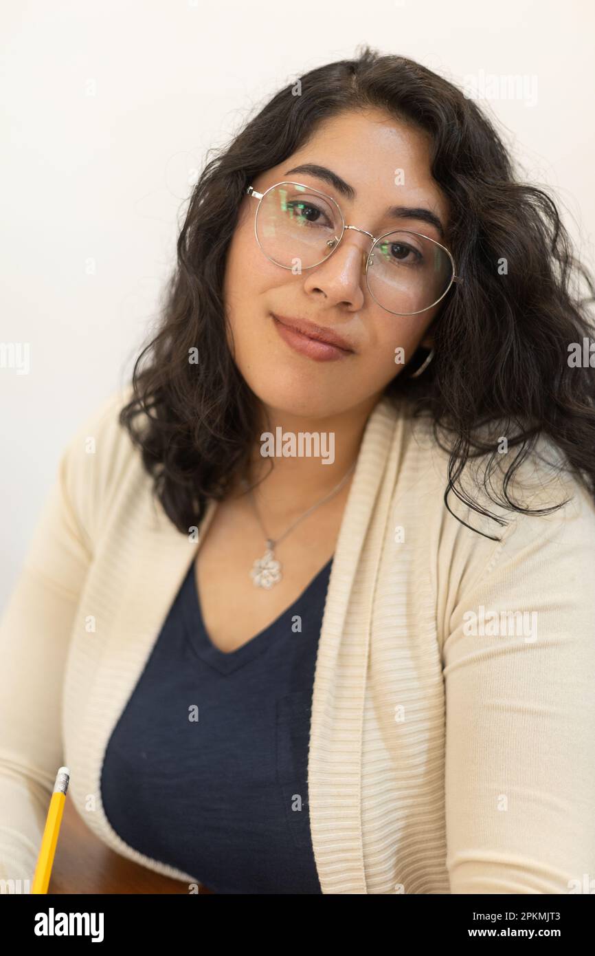 facial features of young woman with short wavy hair wear glasses and necklace as accessory ...