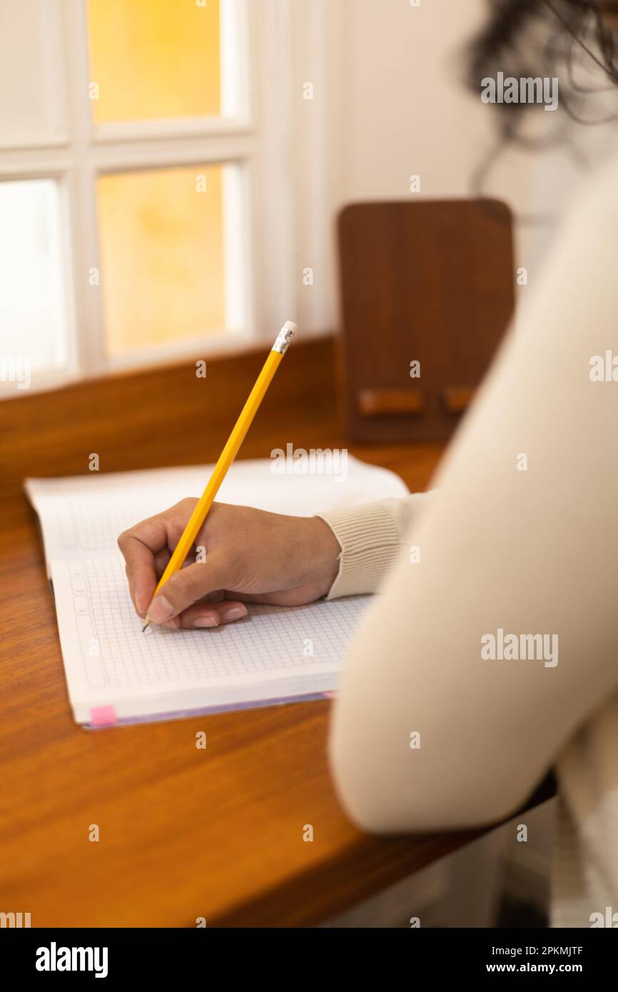 details of a person's hand holding and using to write a pencil ...