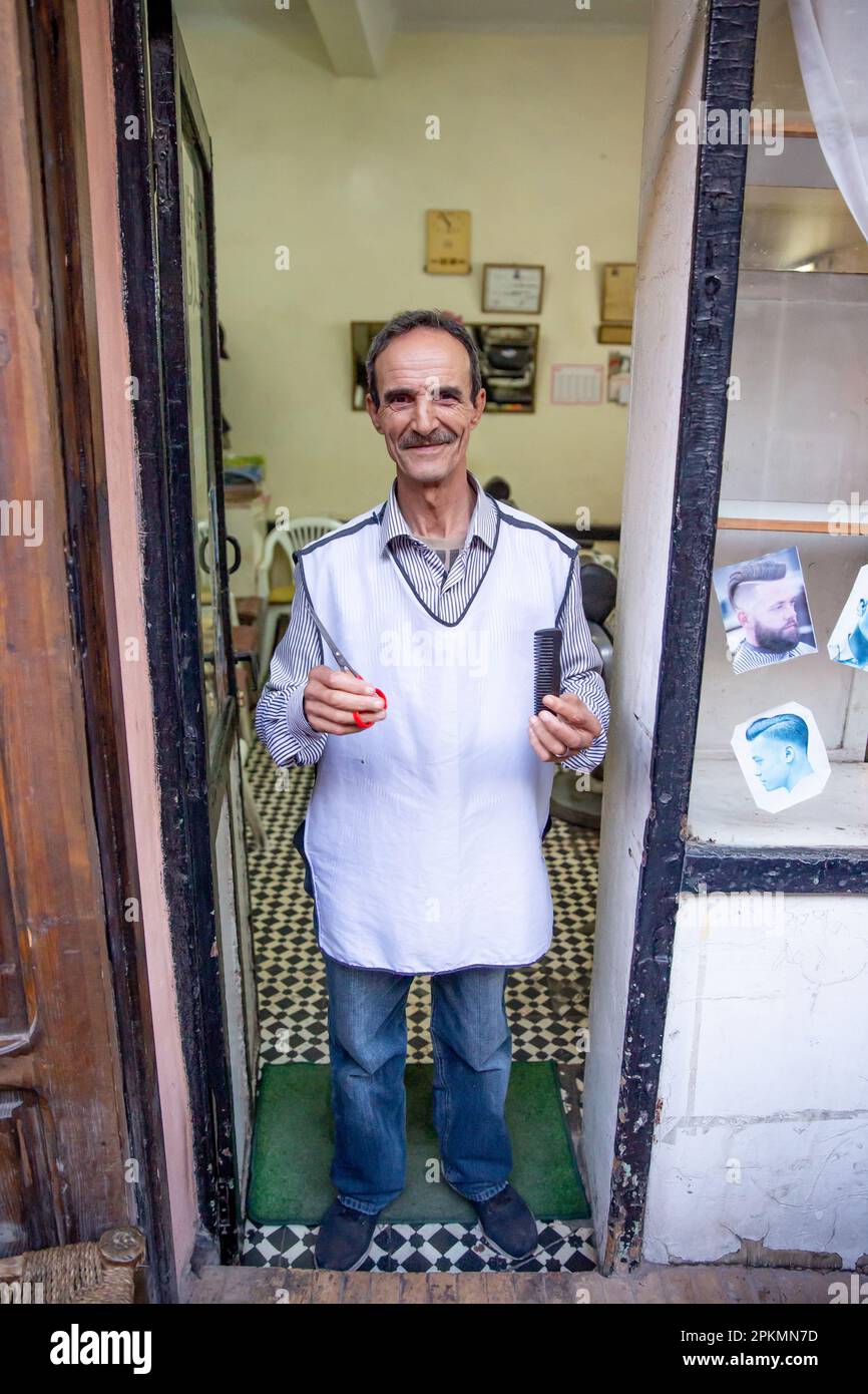 A barber standing in the doorway of his barbershop in Marrakech Morocco ...