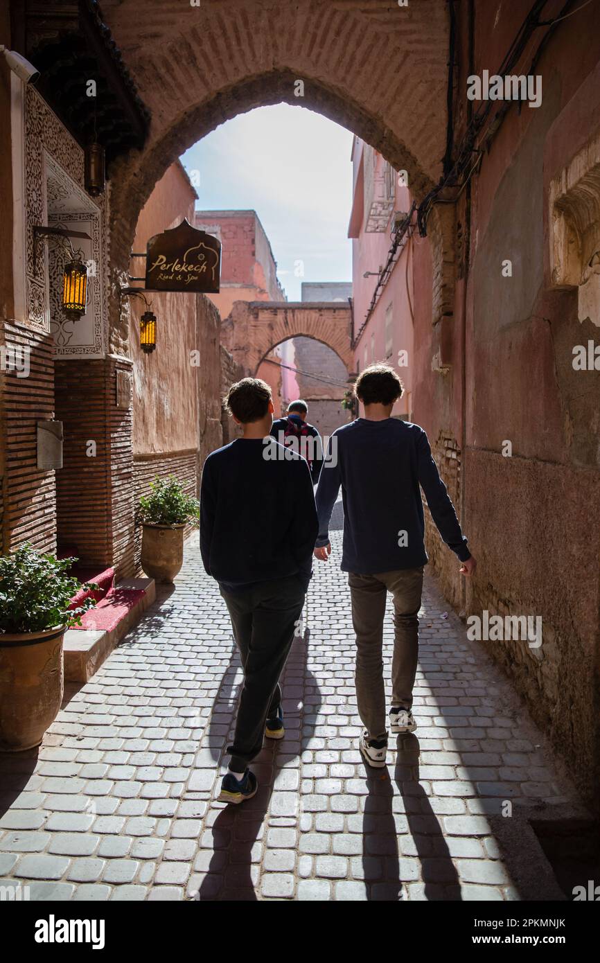 Teen boys walking down an arched alleyway in Marrakech Morocco Stock ...