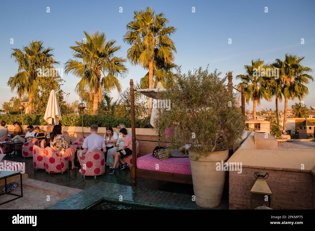 A group of tourists sit and enjoy cocktails at the rooftop bar at the ...