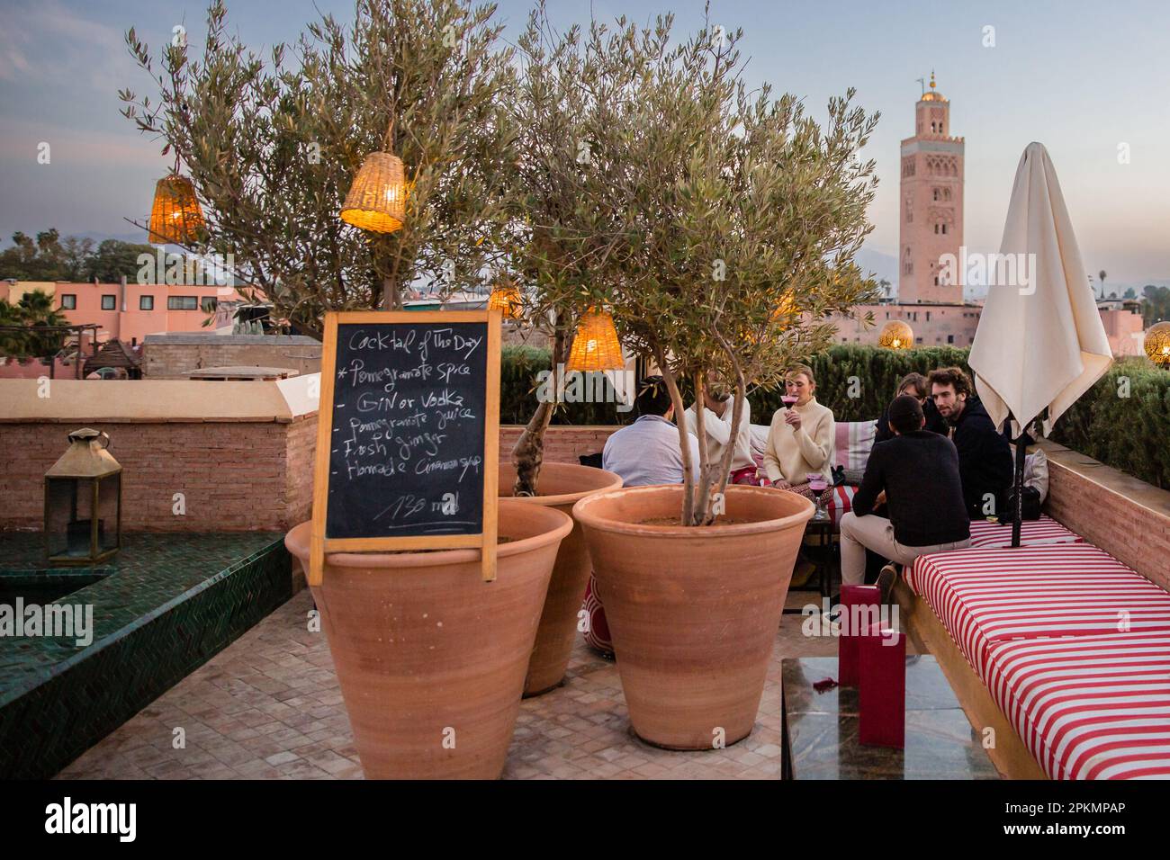 A group of tourists sit and enjoy cocktails at the rooftop bar at the ...