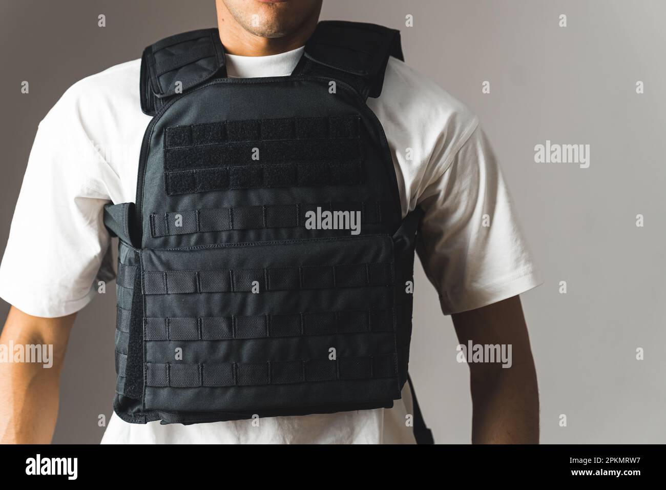 a muscular unknown man in a white T-shirt wearing a bulletproof vest on ...