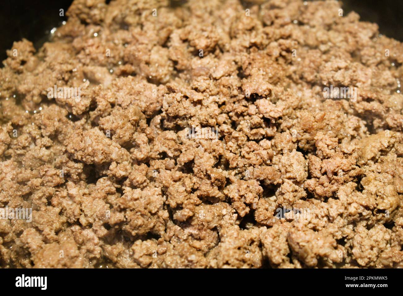 ground beef being fried in frying pan with steam and grease Stock Photo ...