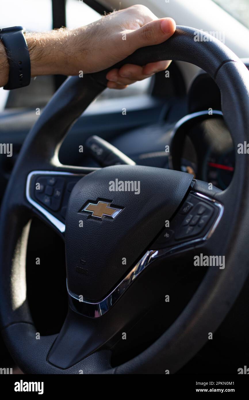 A closeup picture of a male hand on the wheel of the Chevrolet car. The ...
