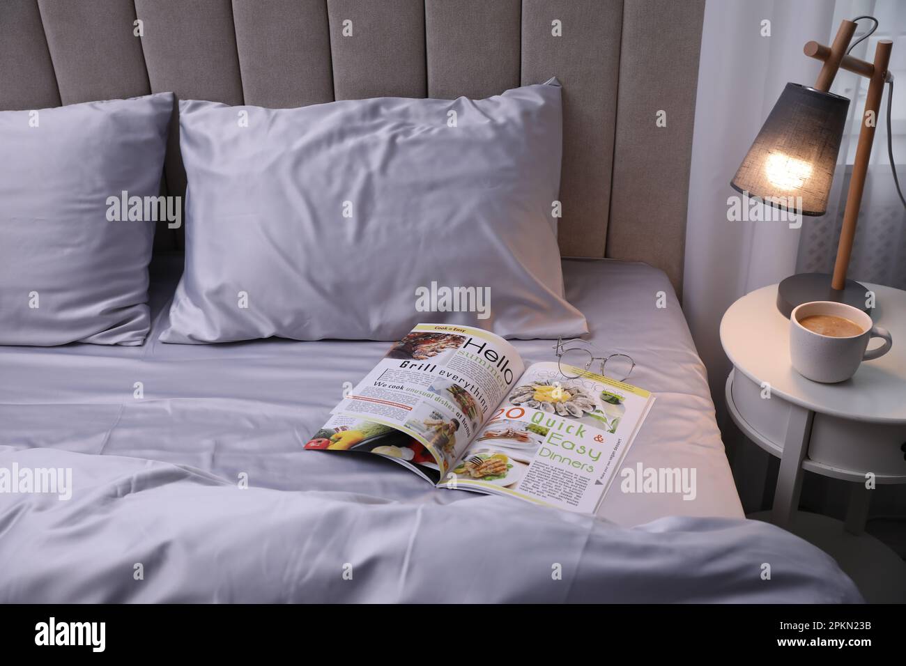 Magazine on bed with soft silky bedclothes in room Stock Photo - Alamy
