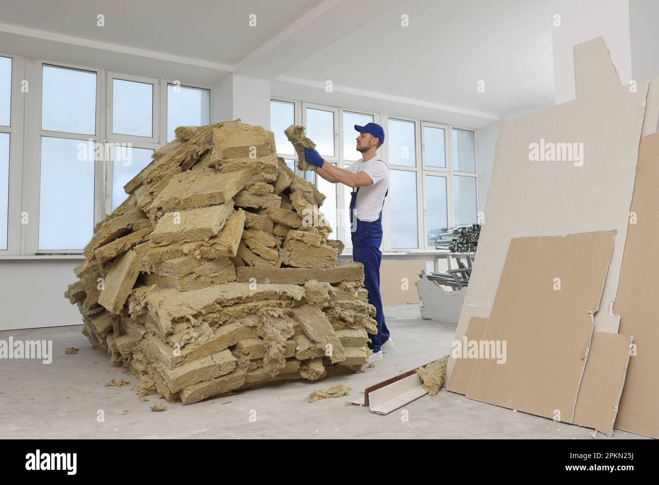 Construction worker with used glass wool in room prepared for ...