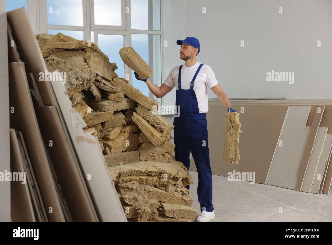 Construction worker with used glass wool in room prepared for ...