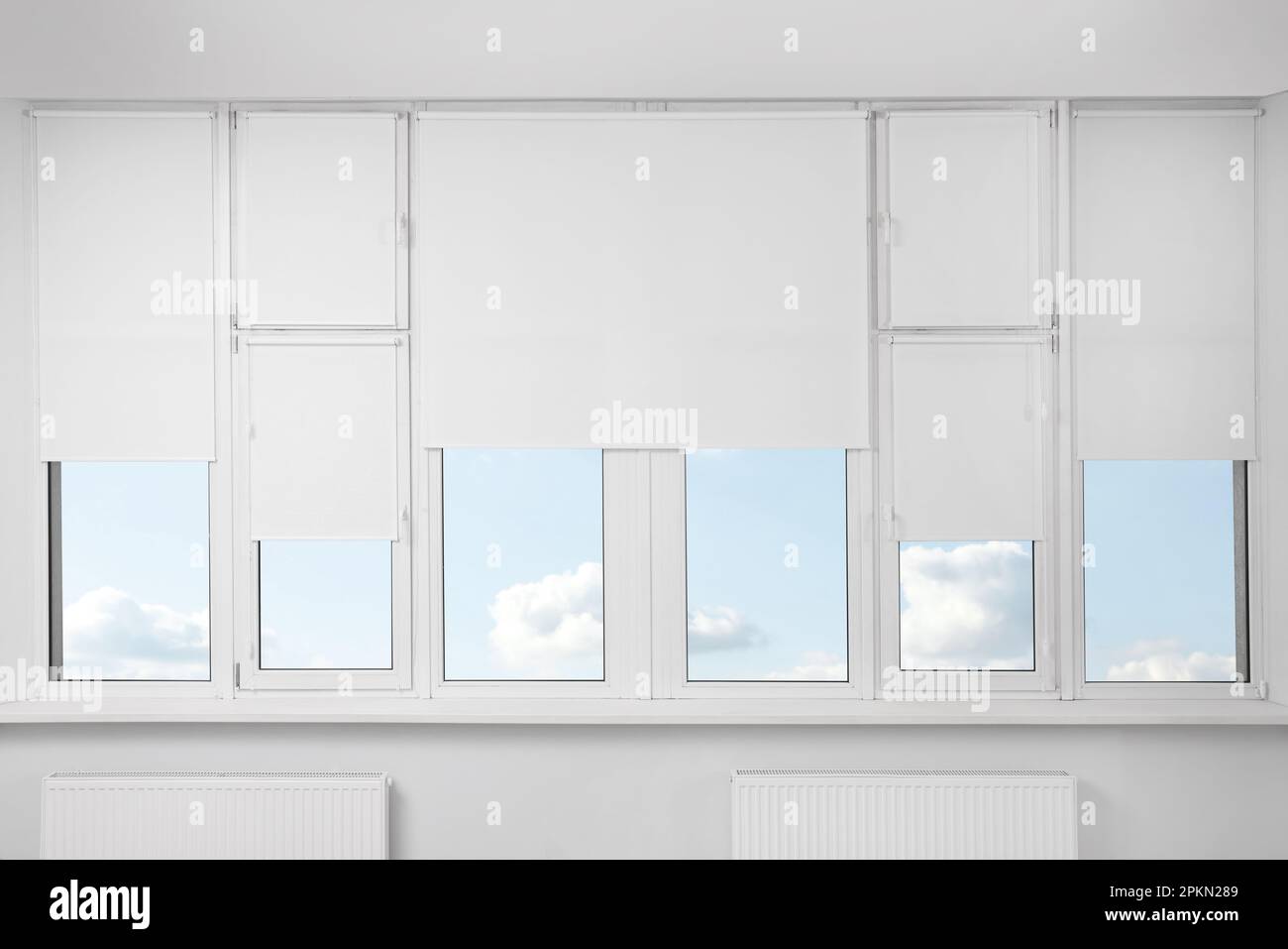 Plastic windows with white roller blinds indoors Stock Photo - Alamy