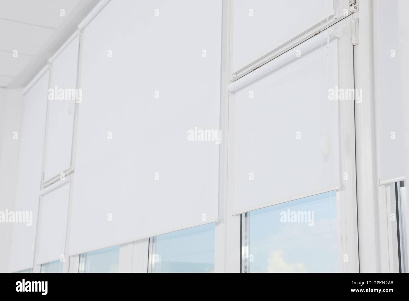 Plastic windows with white roller blinds indoors Stock Photo - Alamy