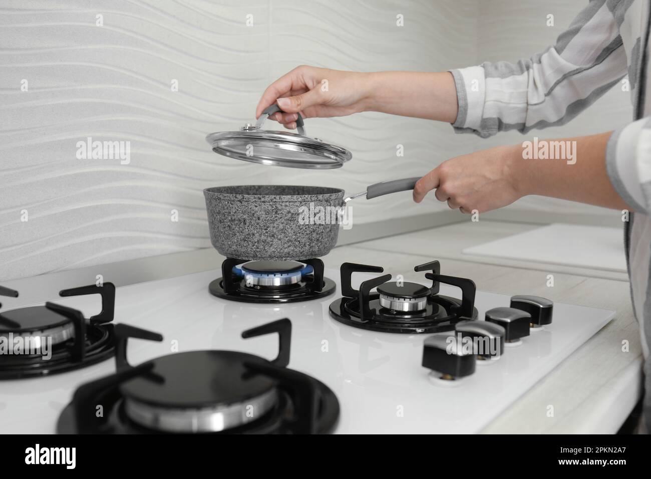 Woman cooking on gas stove in her kitchen hi-res stock photography and ...