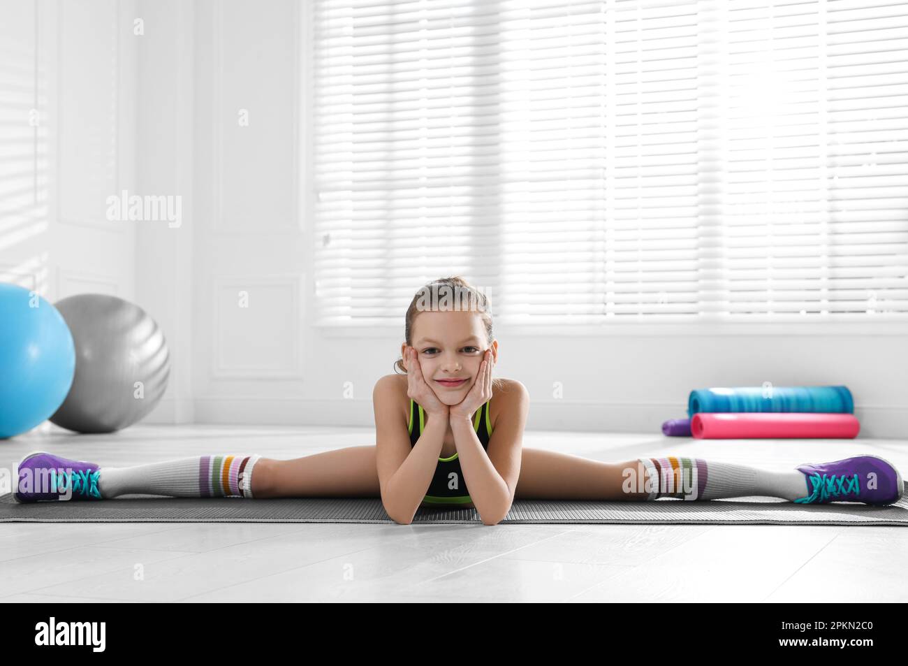 Cute little girl doing gymnastic exercise indoors. Side split Stock ...