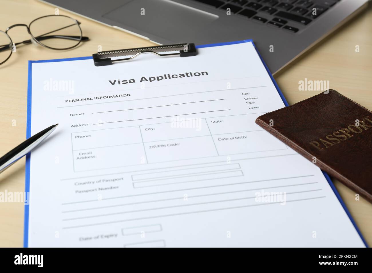 Visa application form for immigration, passport and pen on table ...