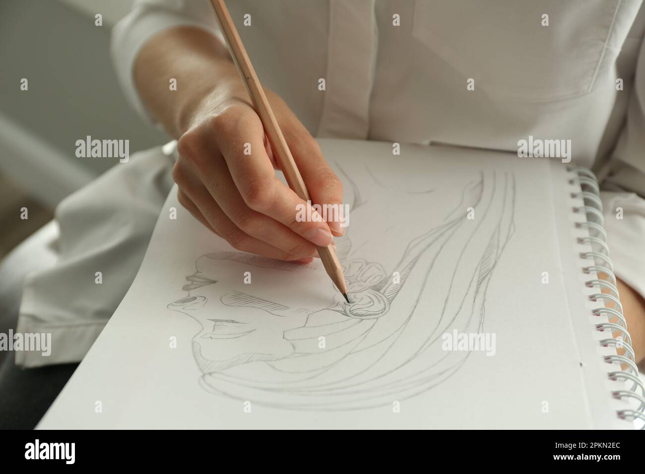 Woman drawing girl's portrait with pencil in notepad, closeup Stock ...