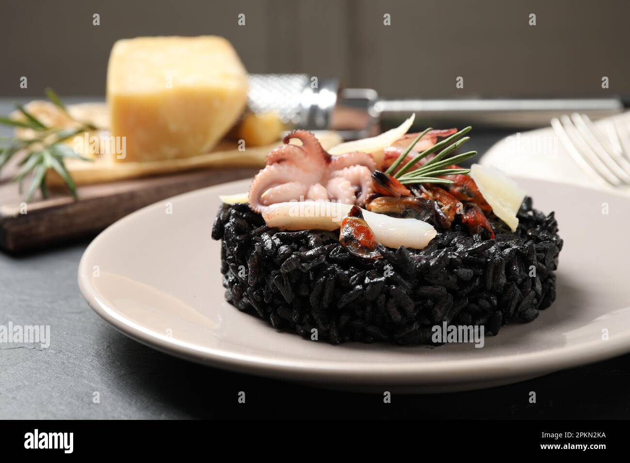 Delicious black risotto with seafood on grey table Stock Photo - Alamy