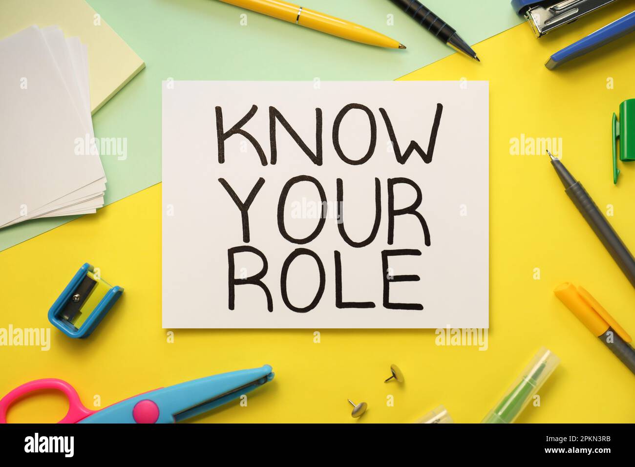 Note with phrase Know Your Role and stationery on color background ...