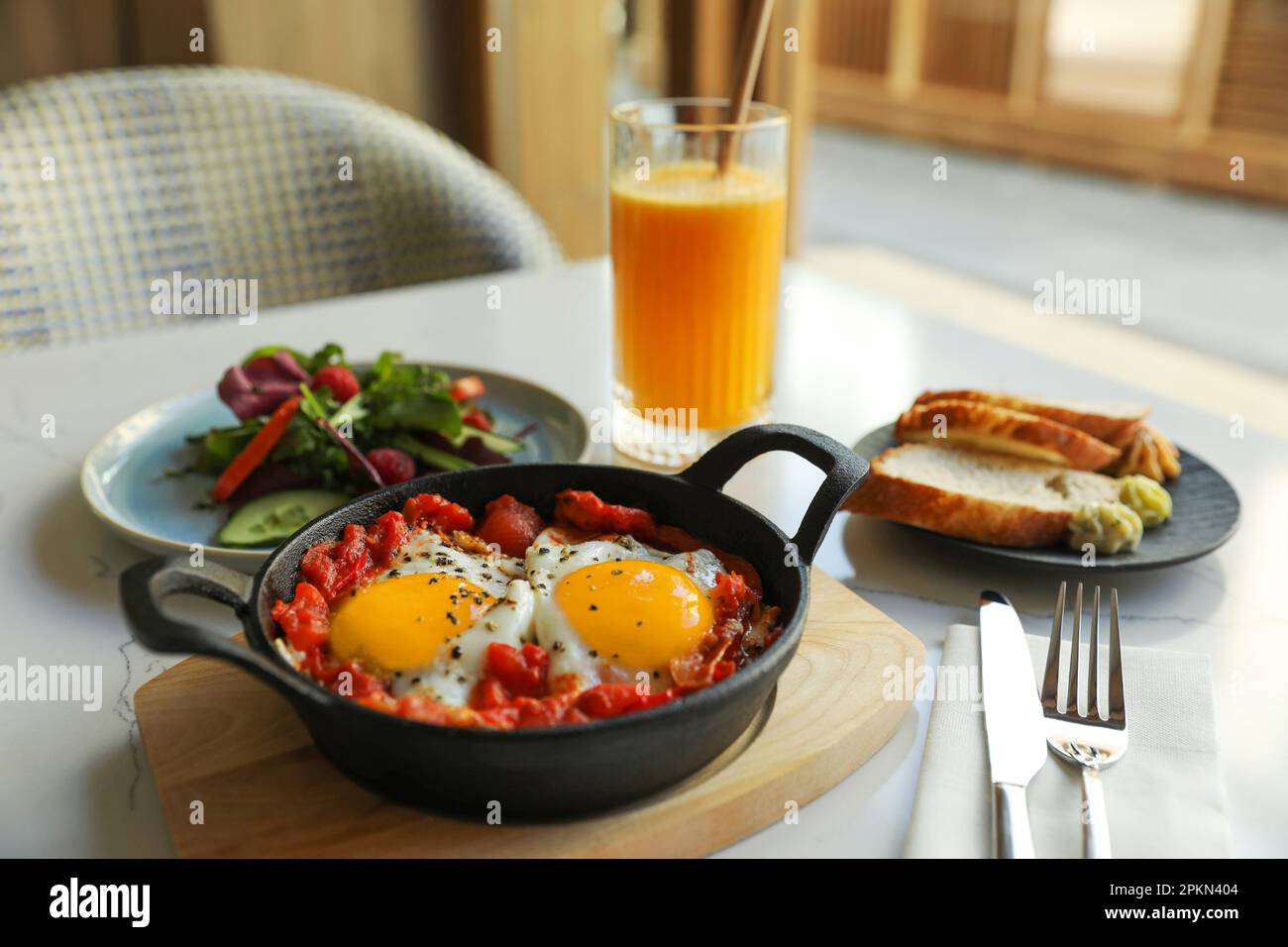 Tasty Shakshouka served on white table indoors. Traditional Arabic dish ...