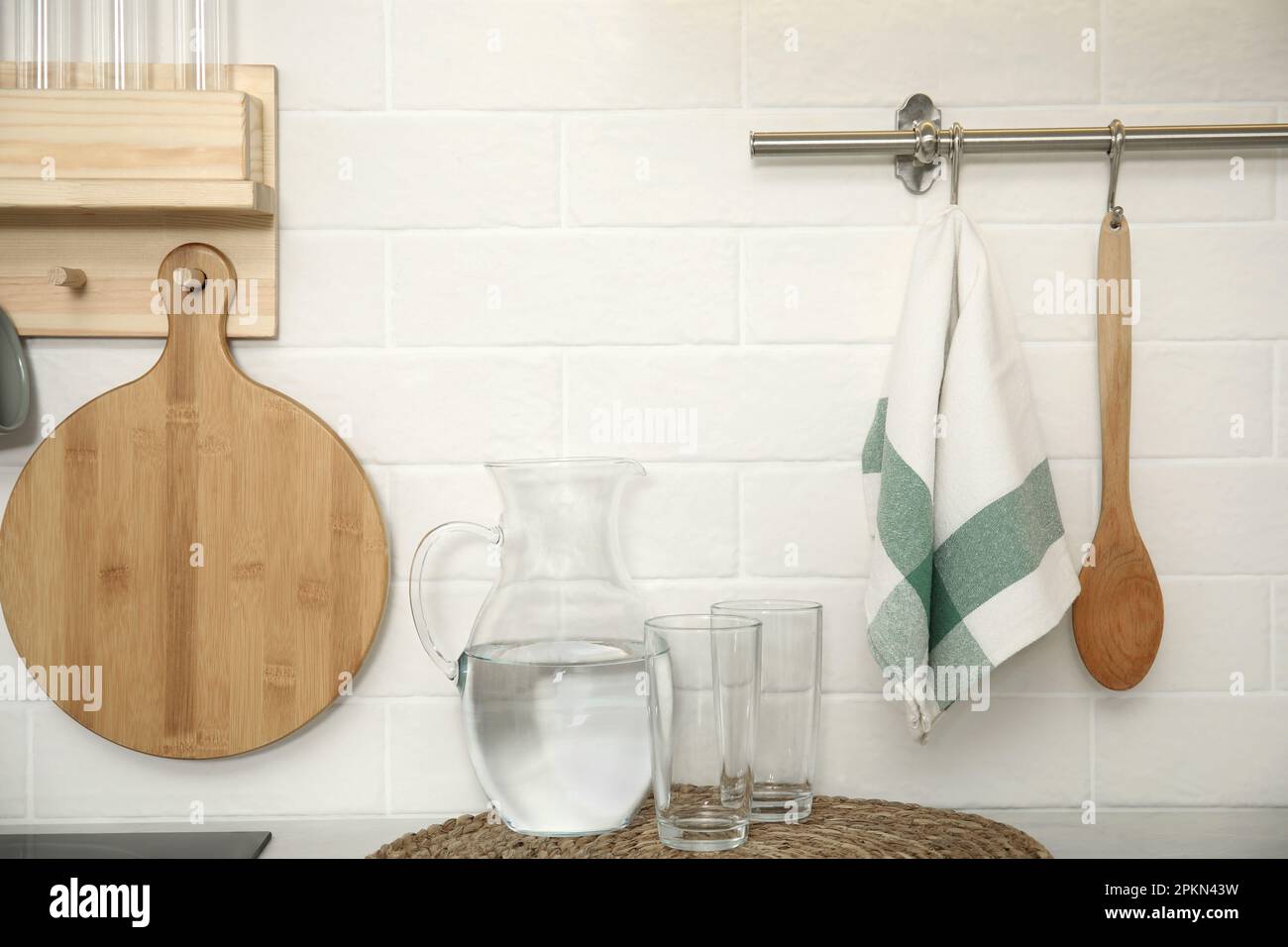 Jug with water, glasses, towel and utensils in kitchen Stock Photo - Alamy