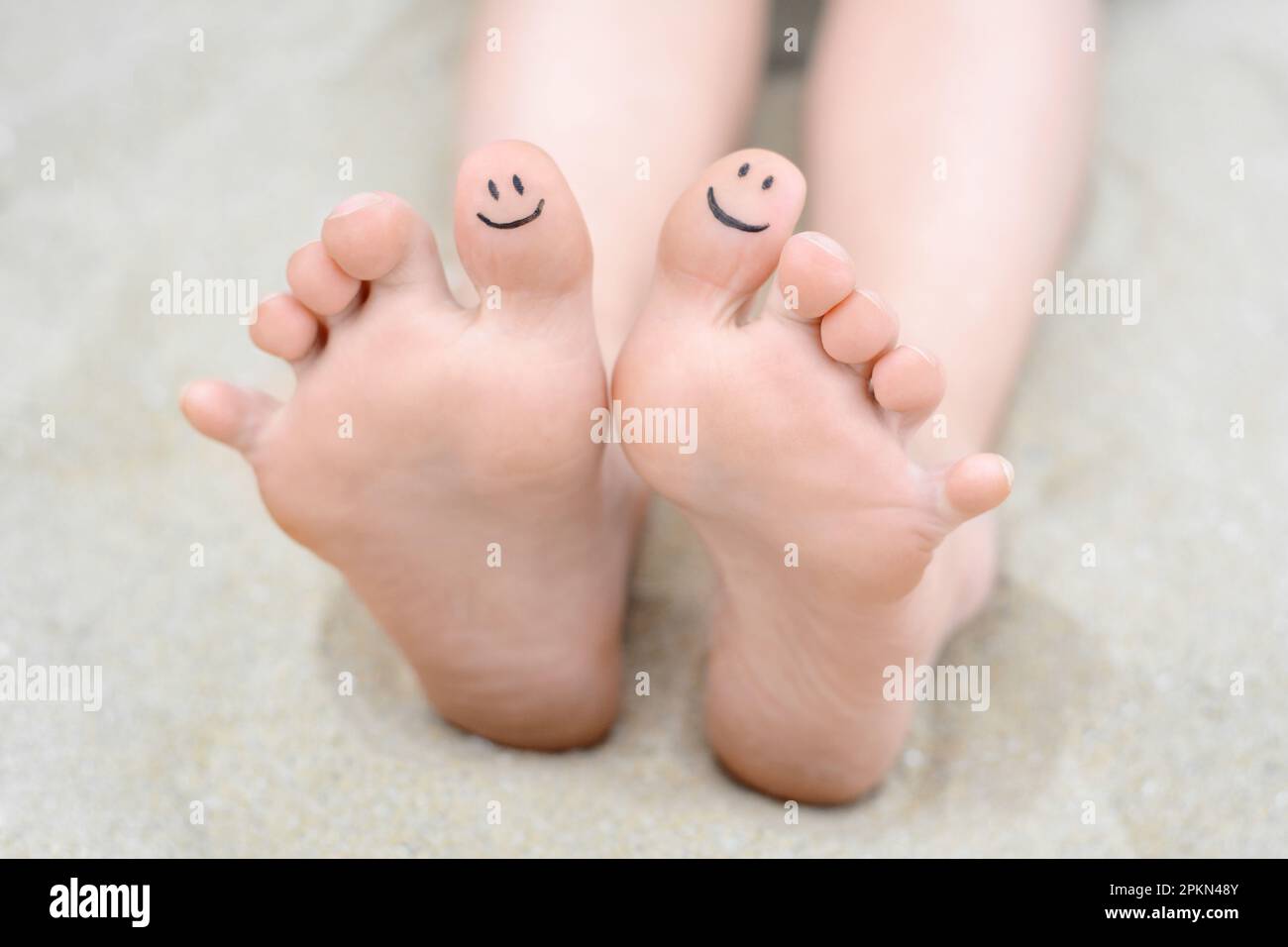 Woman with smiling faces drawn on toes, closeup of foot Stock Photo - Alamy