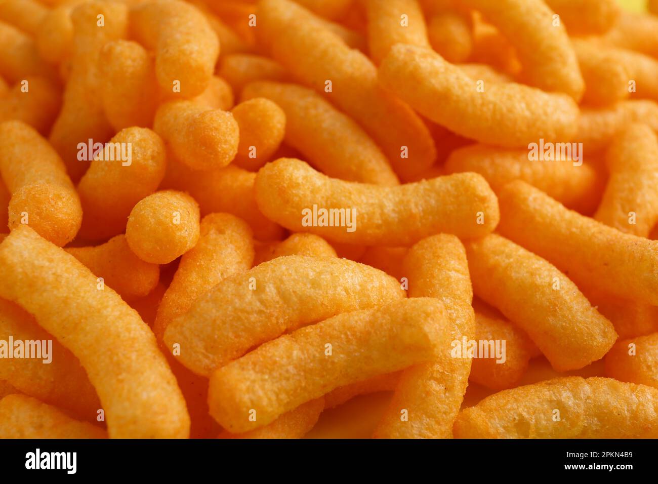 Tasty cheesy corn puffs as background, closeup Stock Photo - Alamy