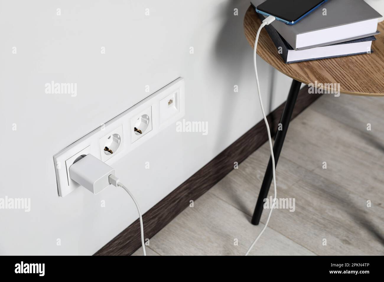 Modern smartphone charging from electric socket indoors Stock Photo - Alamy