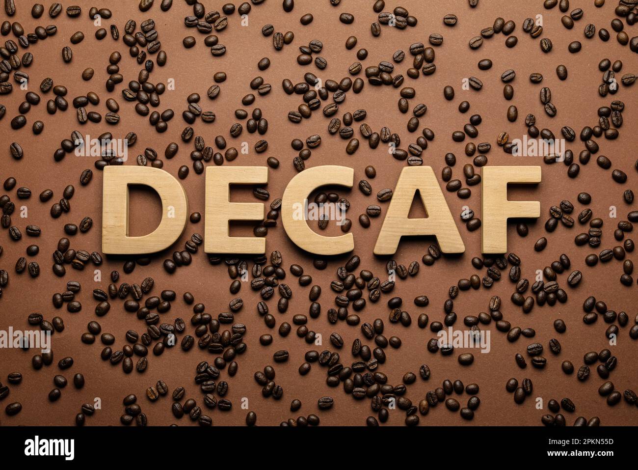 Word Decaf made of wooden letters on brown background with coffee beans ...