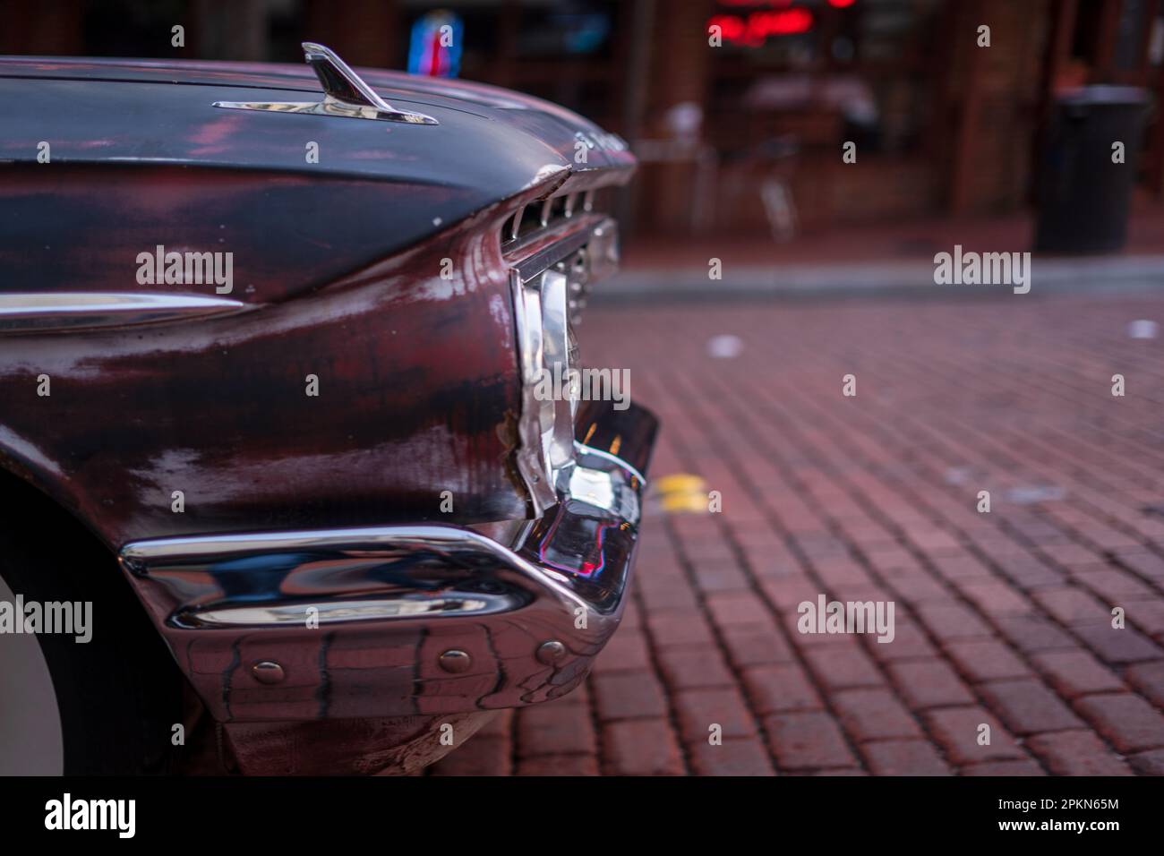 A classic black Chevrolet Impala from the mid-20th century is parked on ...