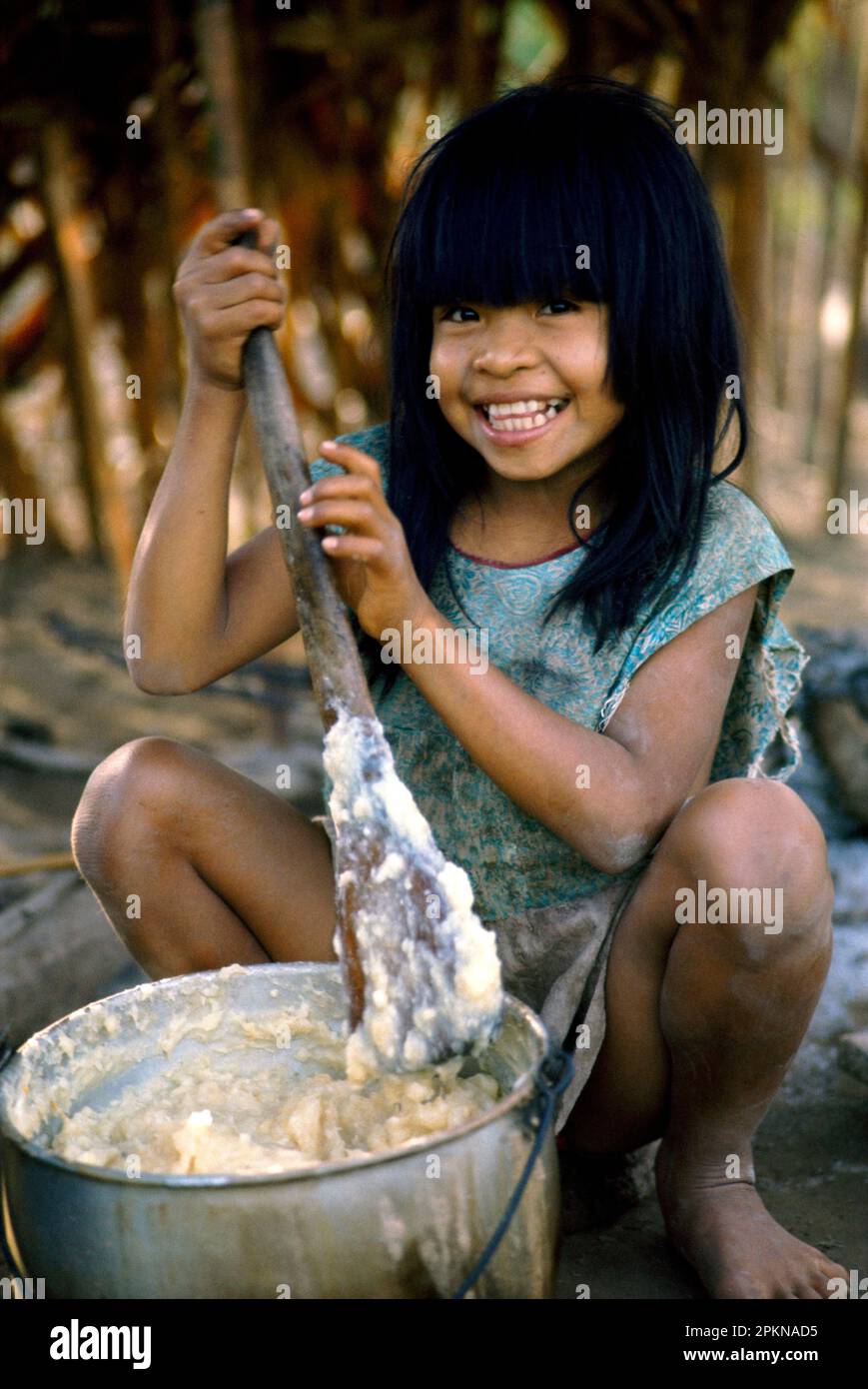 Shipibo Indian girl preparing food in village on shores of Ucayali ...