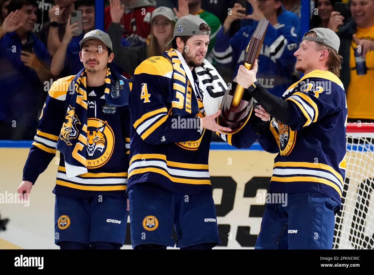 Quinnipiac defenseman Zach Metsa (23) hands the trophy to forward ...