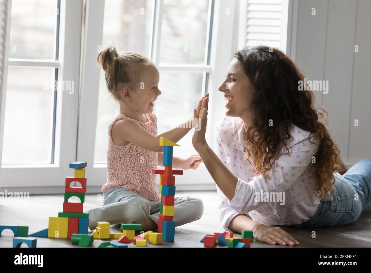 Cheerful mom and kid girl clapping hands, giving high five Stock Photo ...
