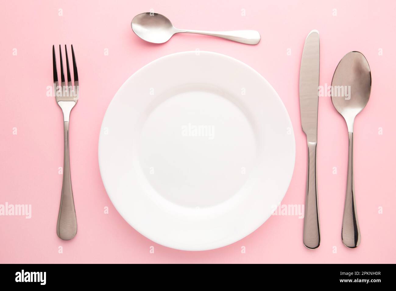 Table setting with white plates, and cutlery - fork, spoon and knife ...