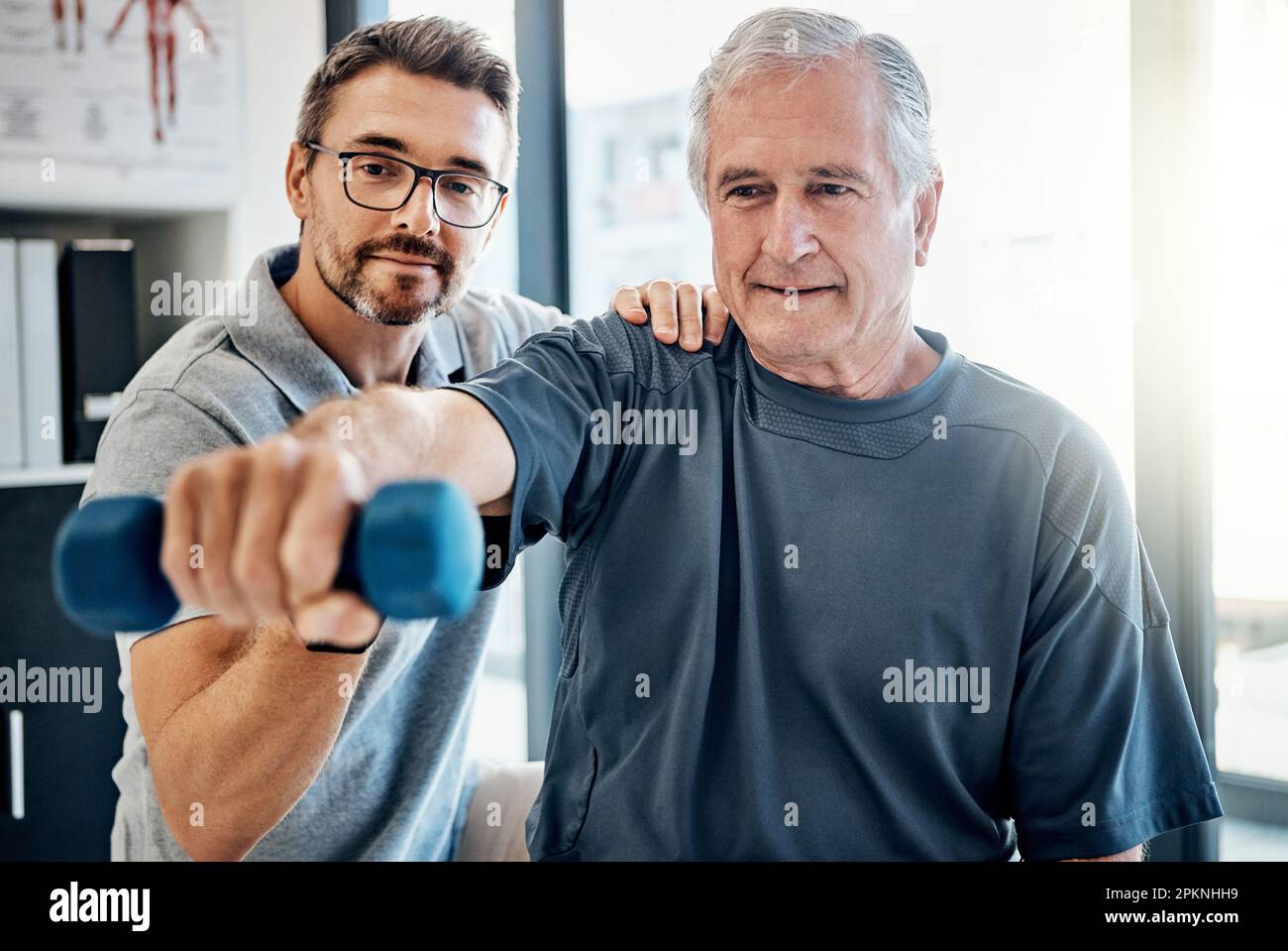 Keep that arm straight now. a friendly physiotherapist helping his ...