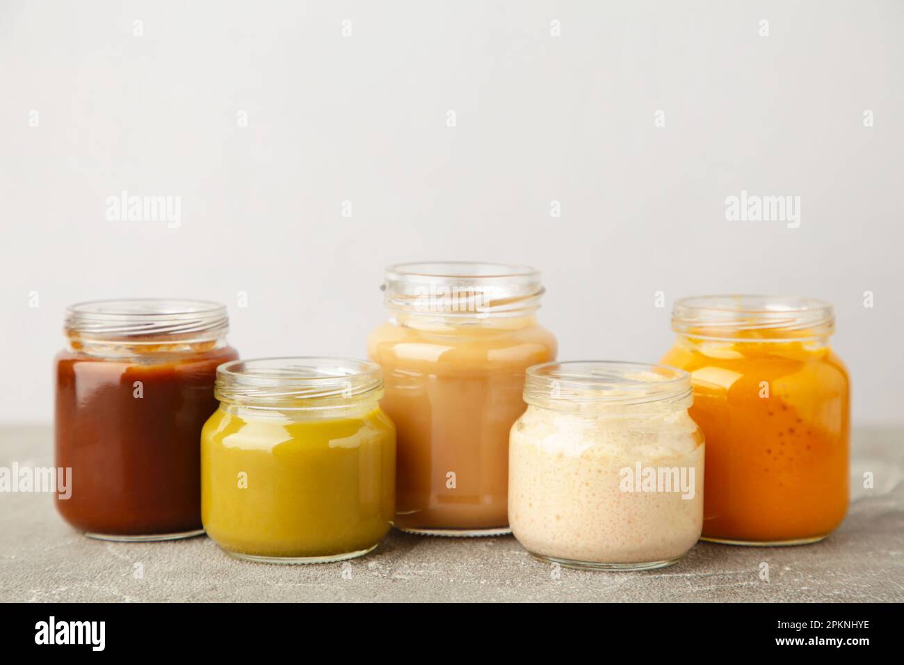 Jars of baby puree on grey concrete background. Top view Stock Photo ...