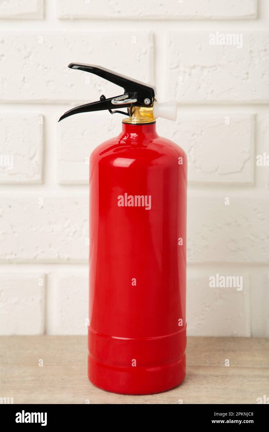 Fire extinguisher on white brick wall with clipping path. Top view ...