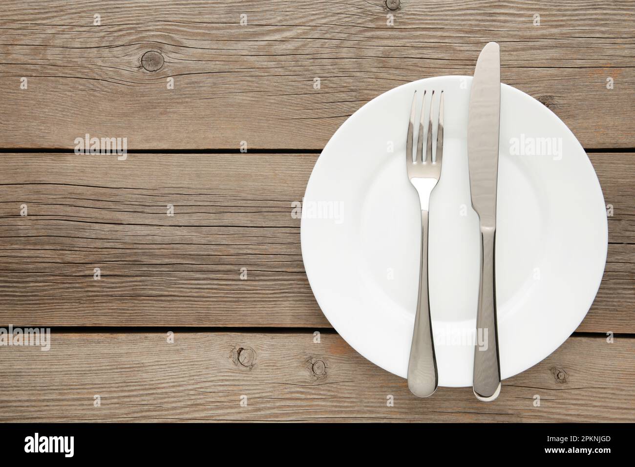Table setting with white plates, and cutlery - fork and knife. Shot ...