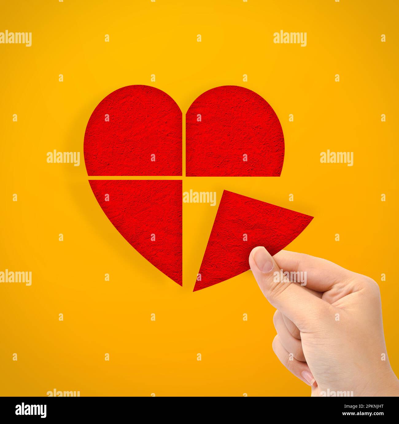 Hand holding cut out heart paper shape on yellow background Stock Photo ...