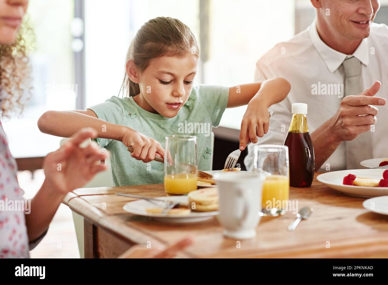 Digging in to something delicious. a family having breakfast together ...