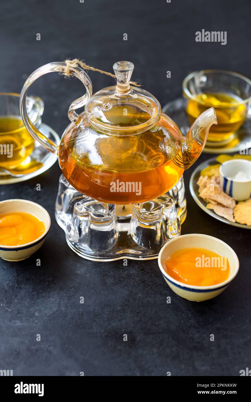 Glass tea pot with plum mango tea and ham,cups and crystalized fruits ...