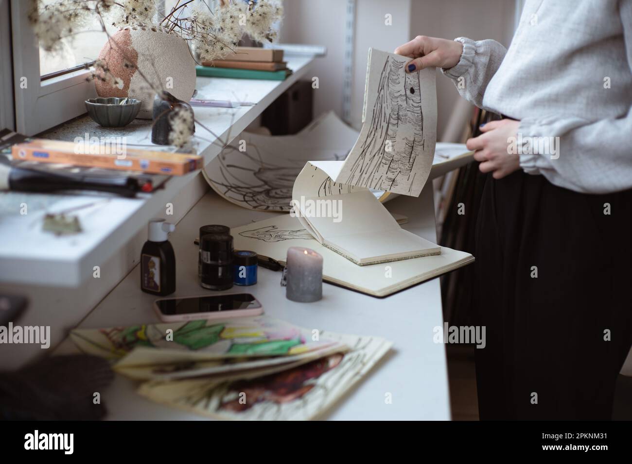 female artist look at her work drawing with pen and black ink. Graphic ...